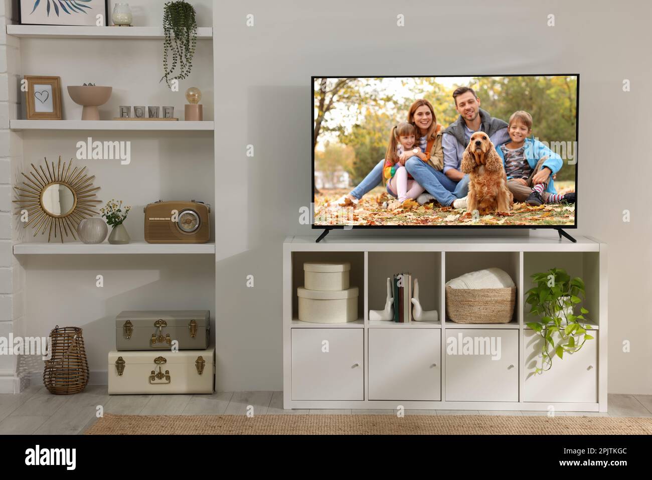 Modern TV set on wooden stand in room Stock Photo - Alamy