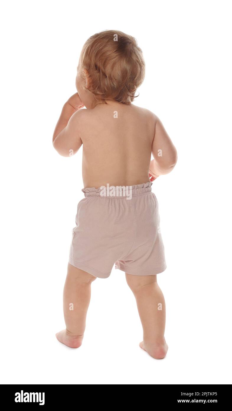Cute baby in shorts learning to walk on white background, back view ...