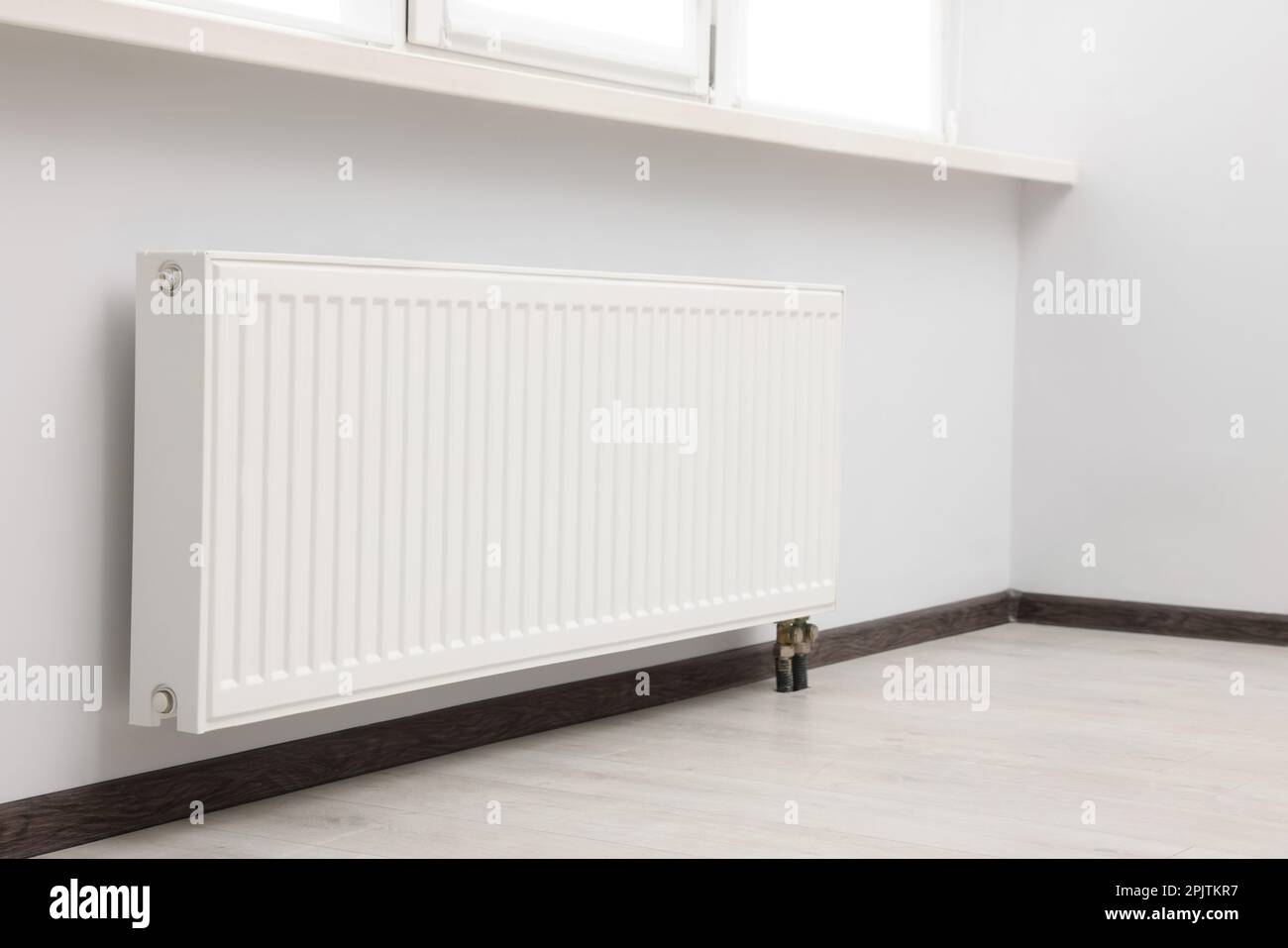 Modern radiator in room. Central heating system Stock Photo - Alamy