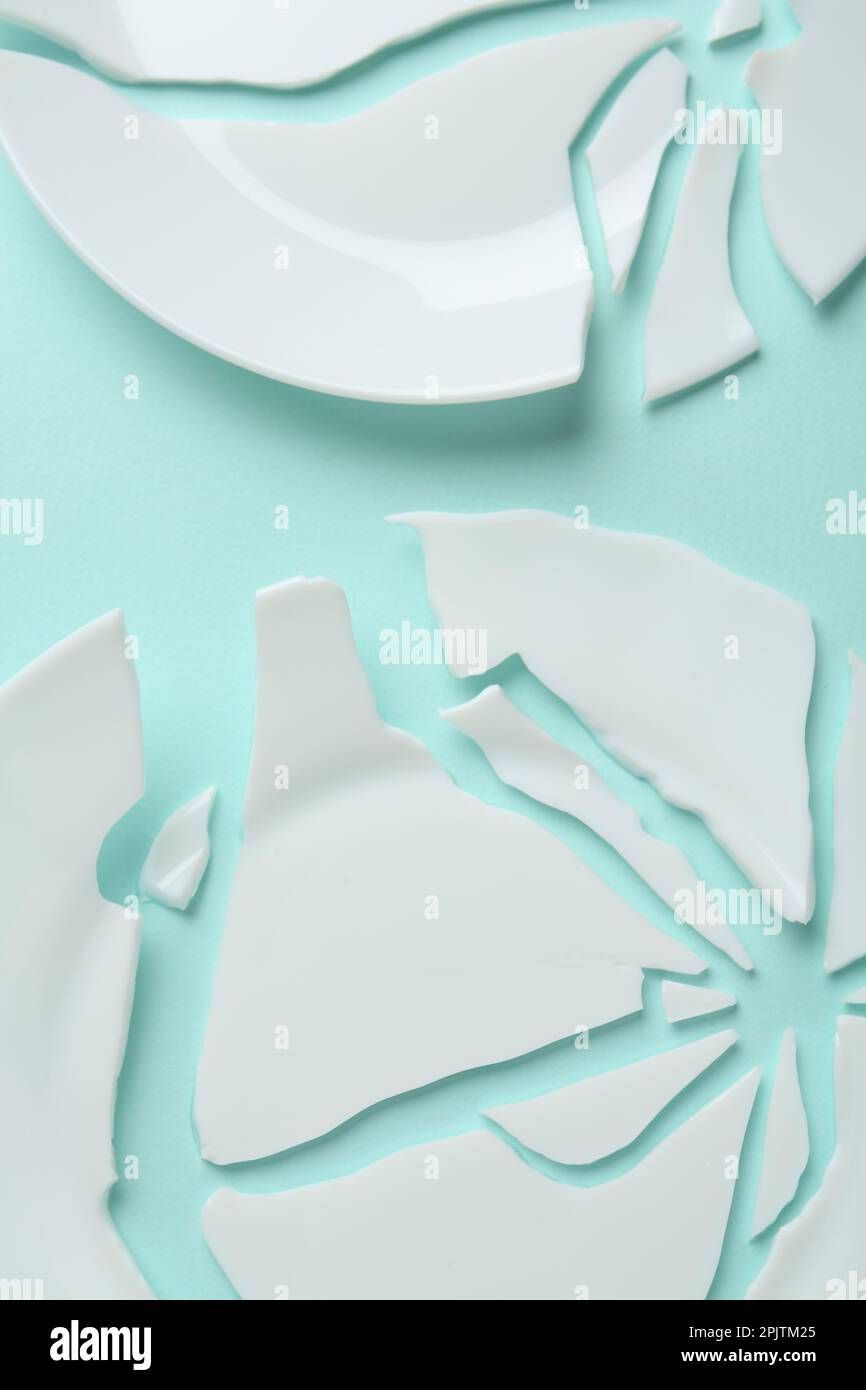 Two broken ceramic plates on light blue background, flat lay Stock ...
