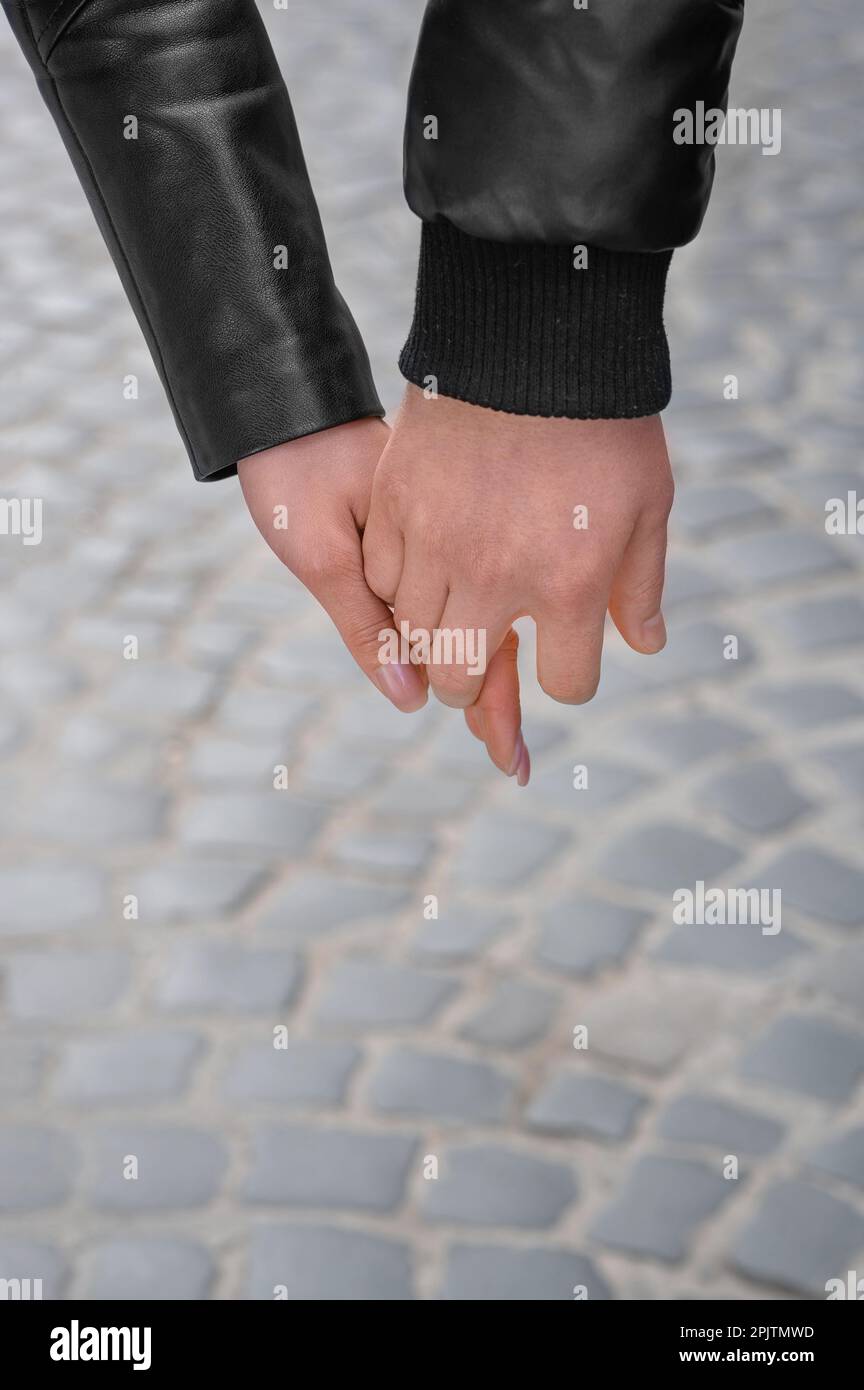 Lovely couple holding hands together outdoors, closeup. Romantic date ...