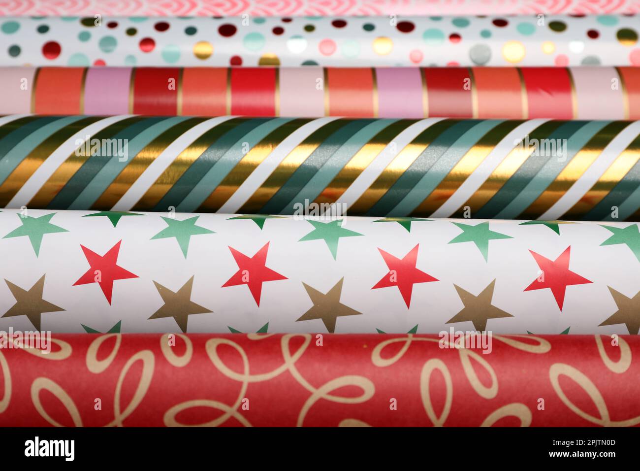 Different colorful wrapping paper rolls as background, closeup Stock ...