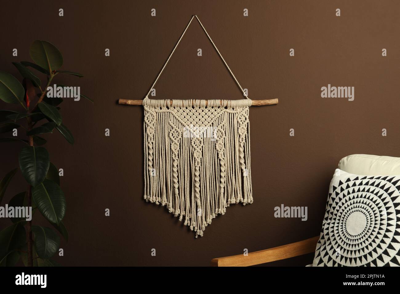 Beautiful macrame hanging on brown wall in room. Decorative element ...