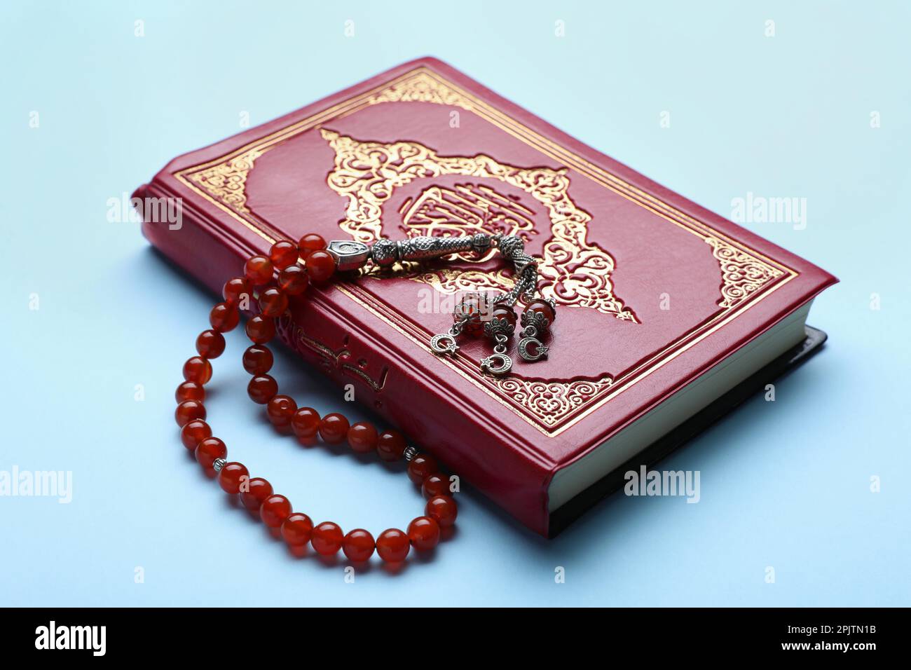 Muslim prayer beads and Quran on light blue background Stock Photo - Alamy