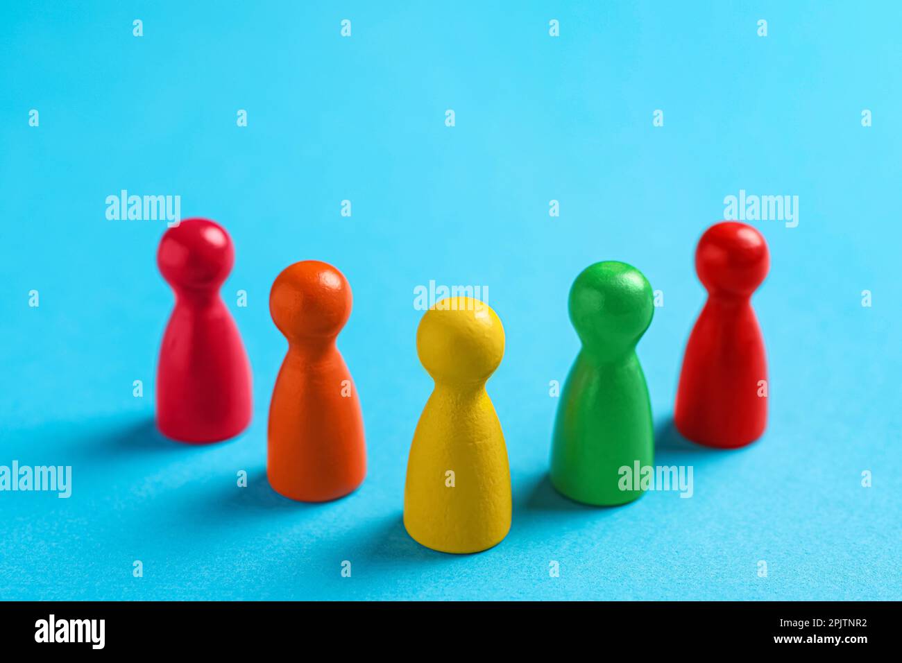 Colorful pawns on light blue background, closeup. Social inclusion ...