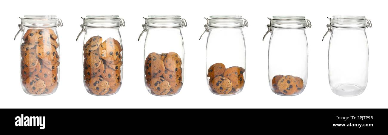 Glass jars with tasty chocolate chip cookies and empty one on white ...