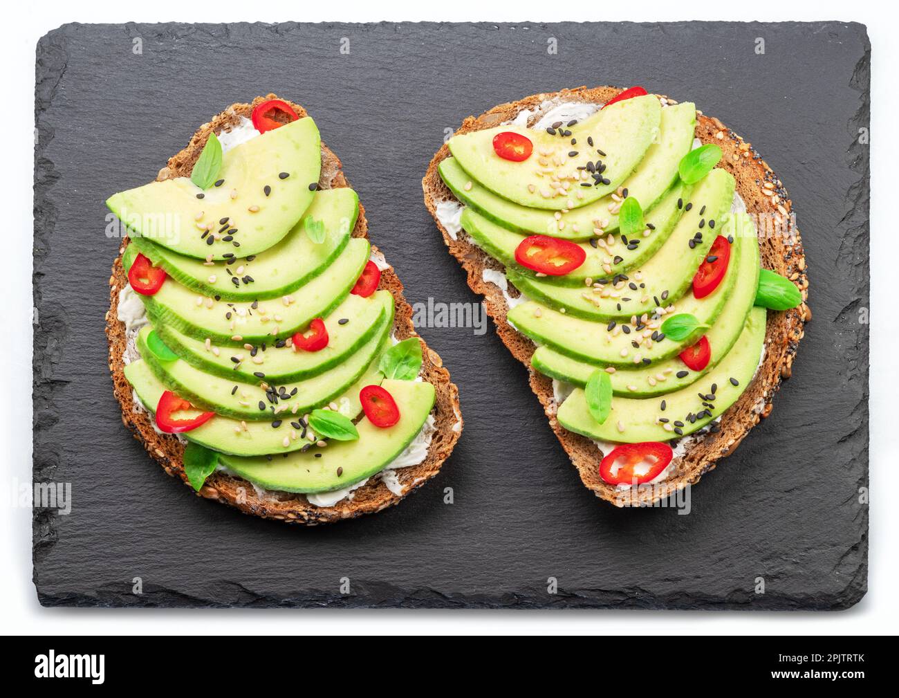 Avocado toasts - bread with avocado slices, pieces of red pepper and ...