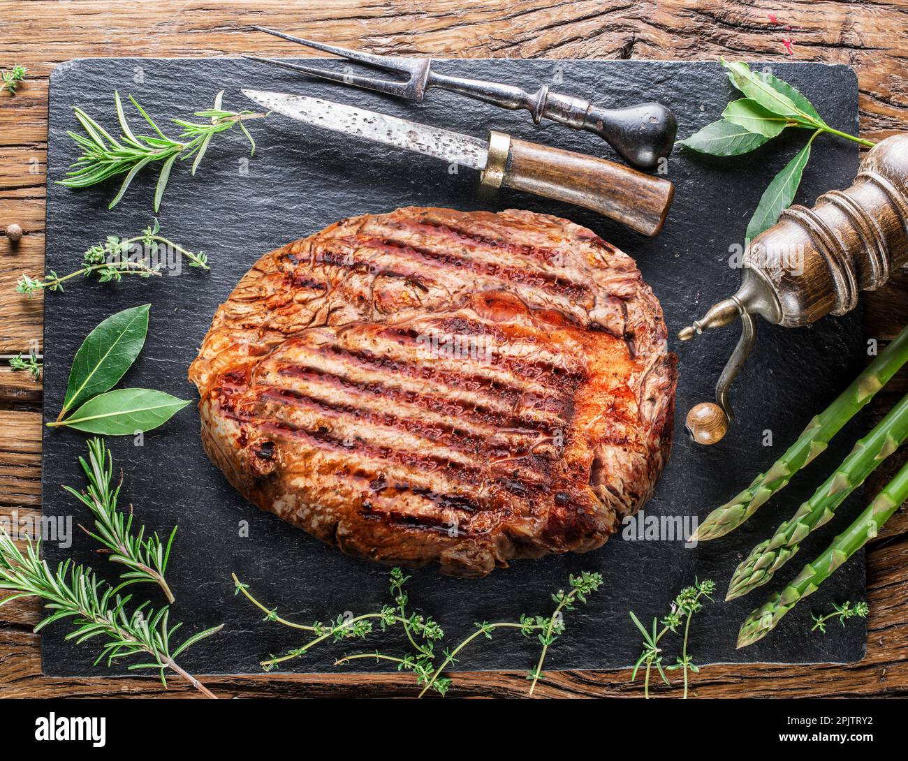 Grilled delicious ribeye steak and variety of herbs arranged as a frame ...