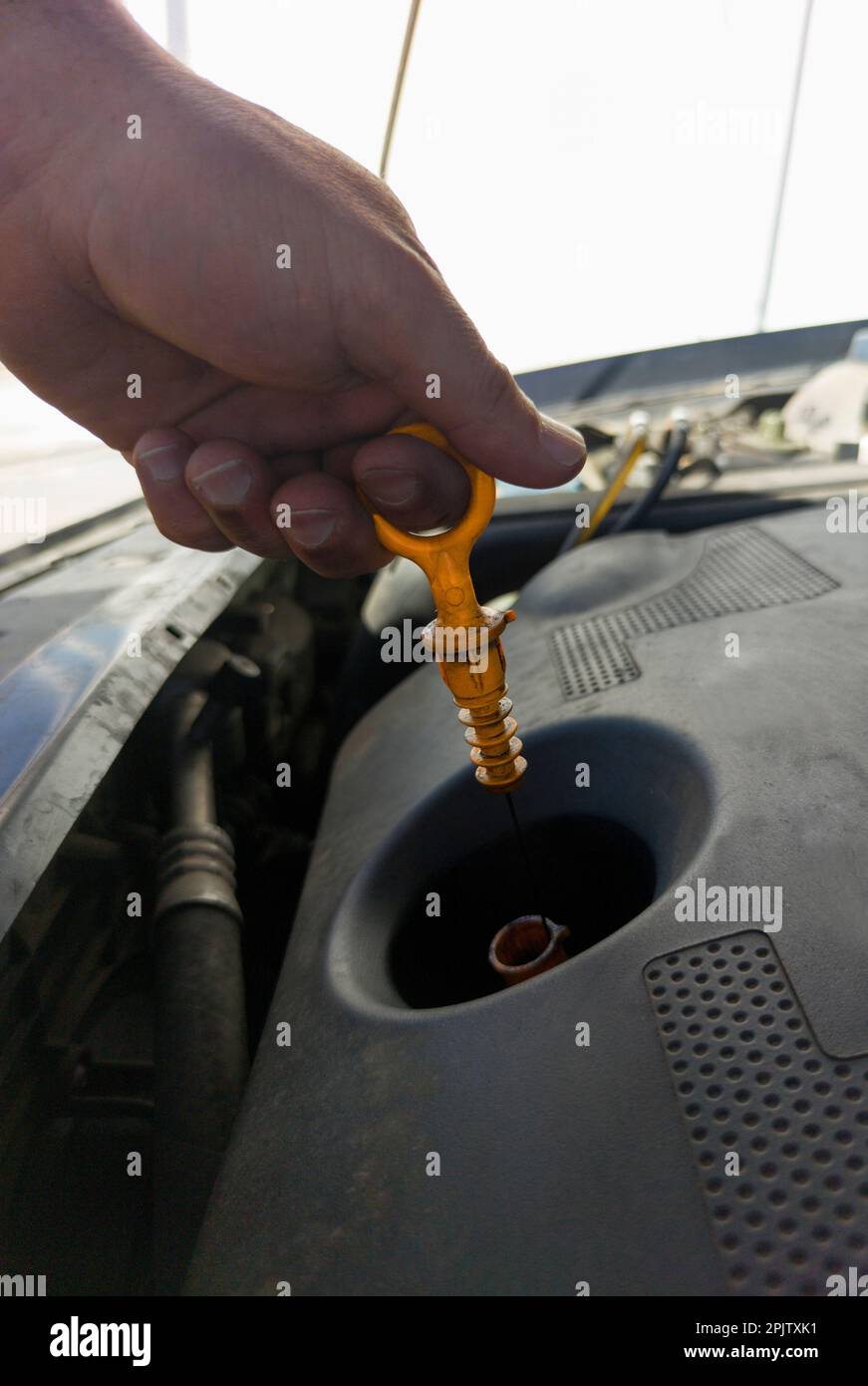 Man checking his oil level from old diesel engine. Petrol station ...