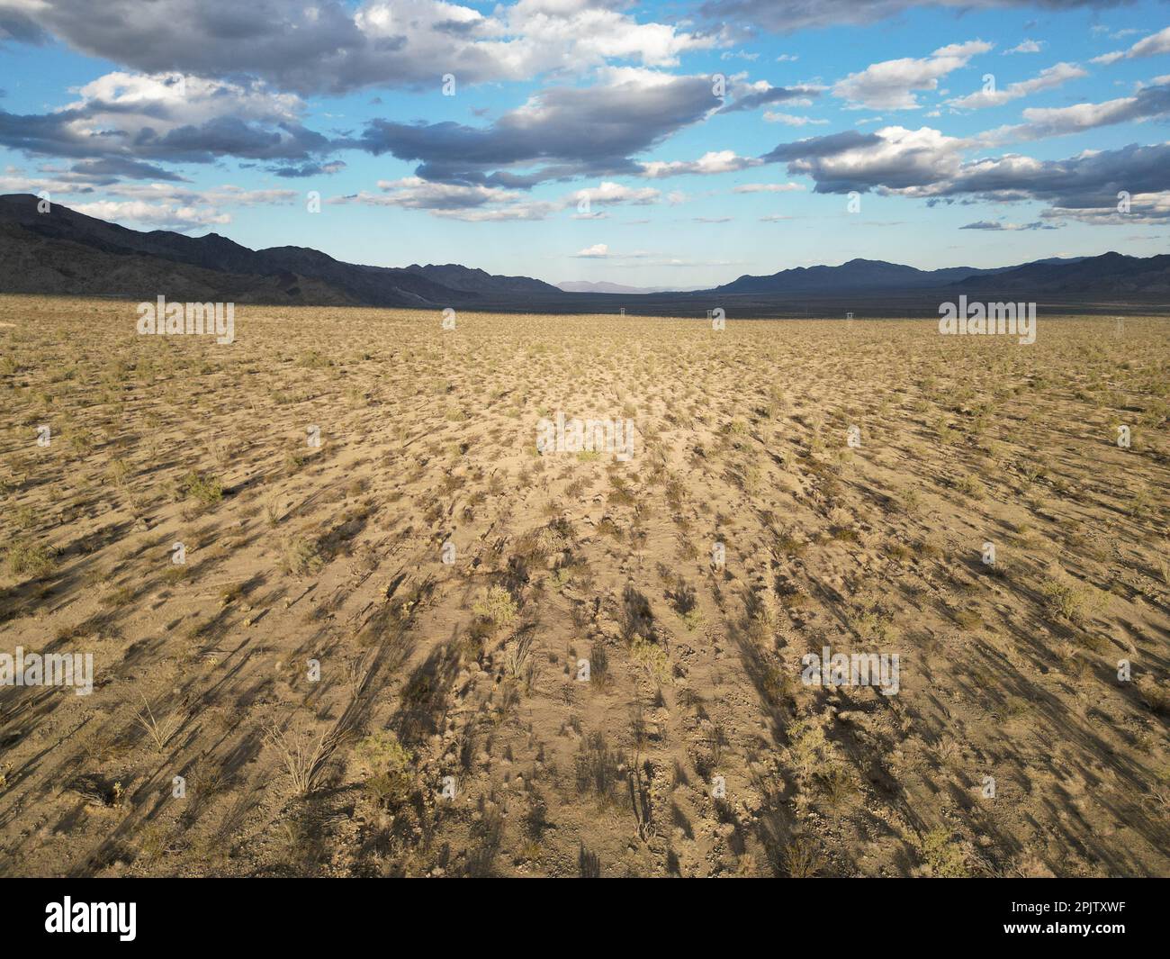 A barren landscape featuring a dirt-covered terrain, with distant ...