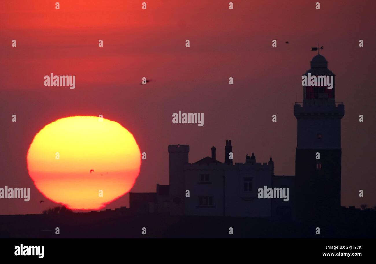 The sun rises behind Coquet island lighthouse which sits 1.2 km off the ...