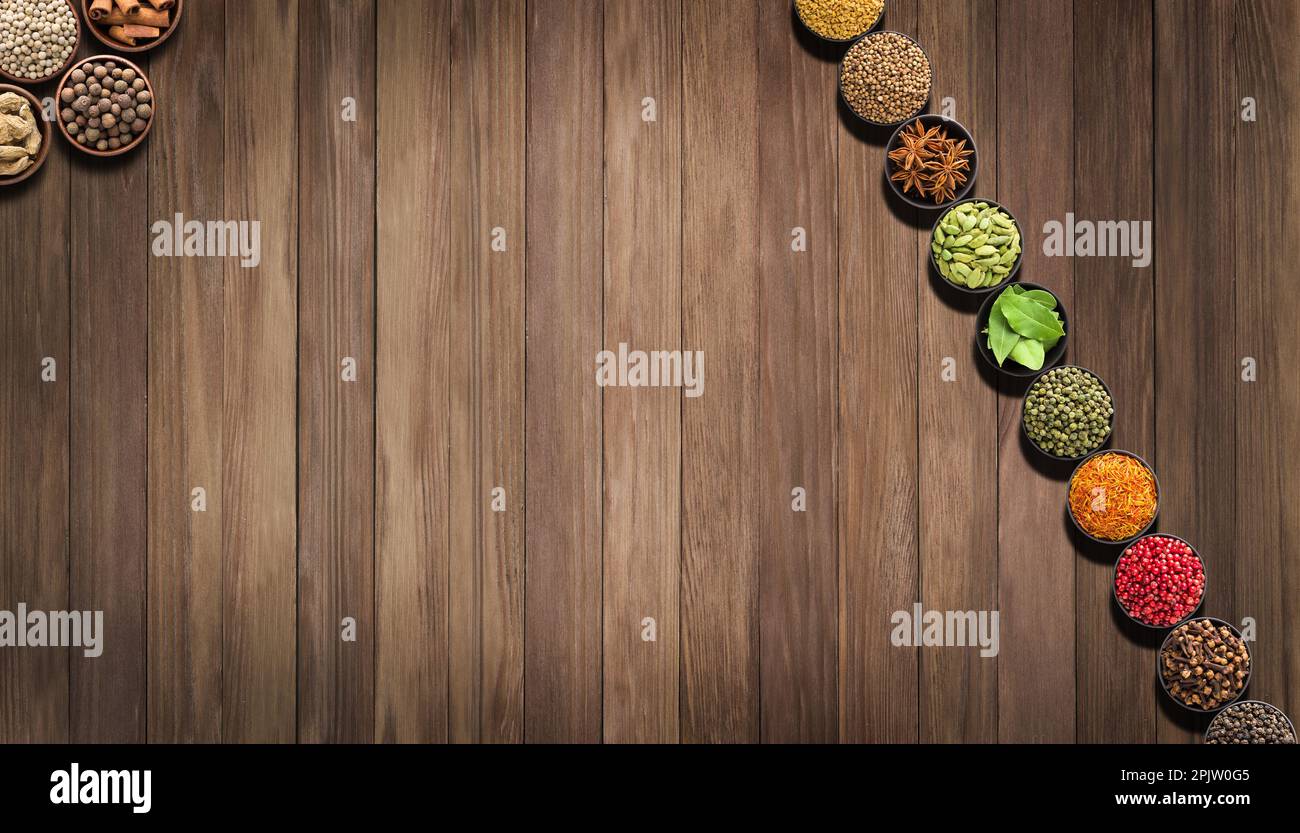 set colorful seasonings on wooden table. Background of spices and herbs ...