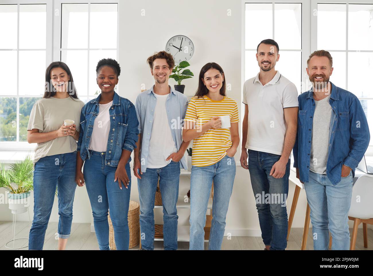 Group of multiracial young people standing in row posing for photo ...