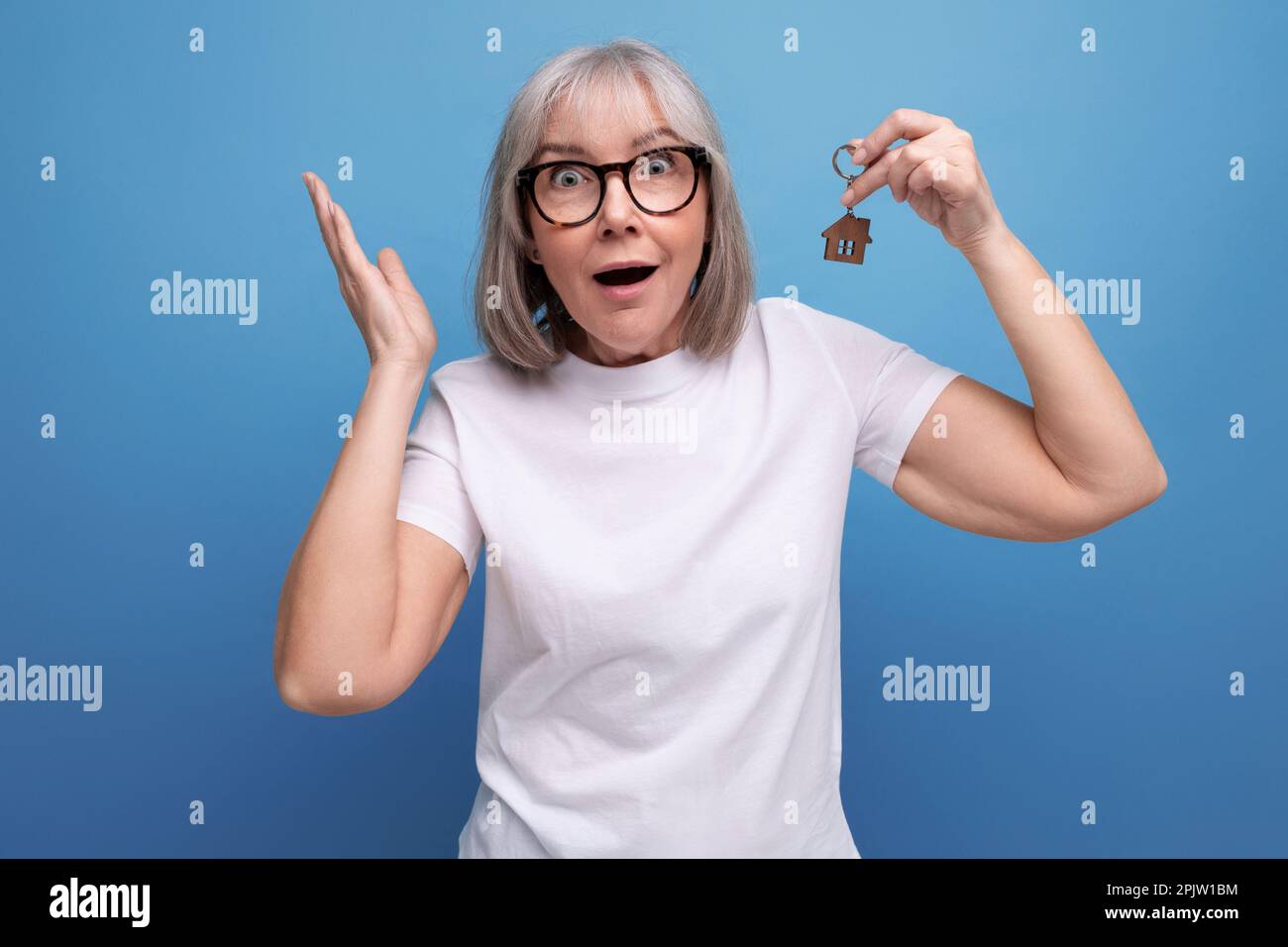 social insurance. mature woman holding secure keys on studio background ...