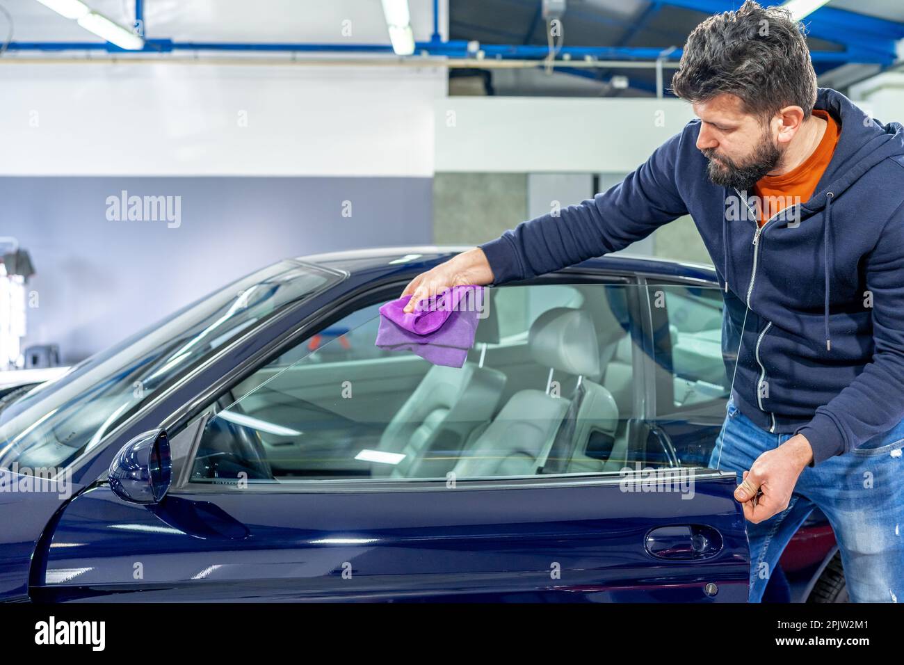 manual cleaning of luxury car windows with a microfiber towel in the ...