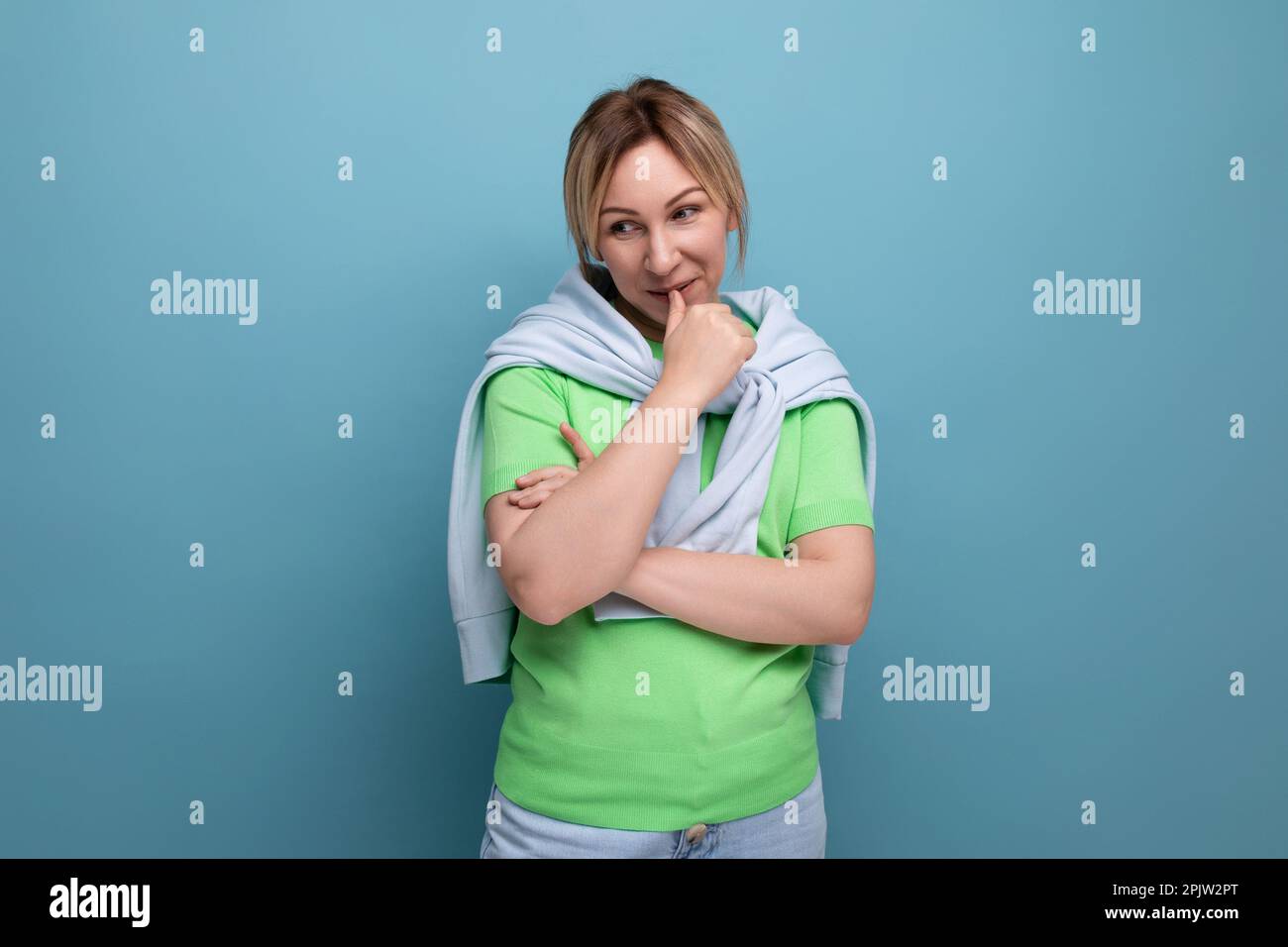 portrait of a blond positive modest young woman in a casual outfit ...