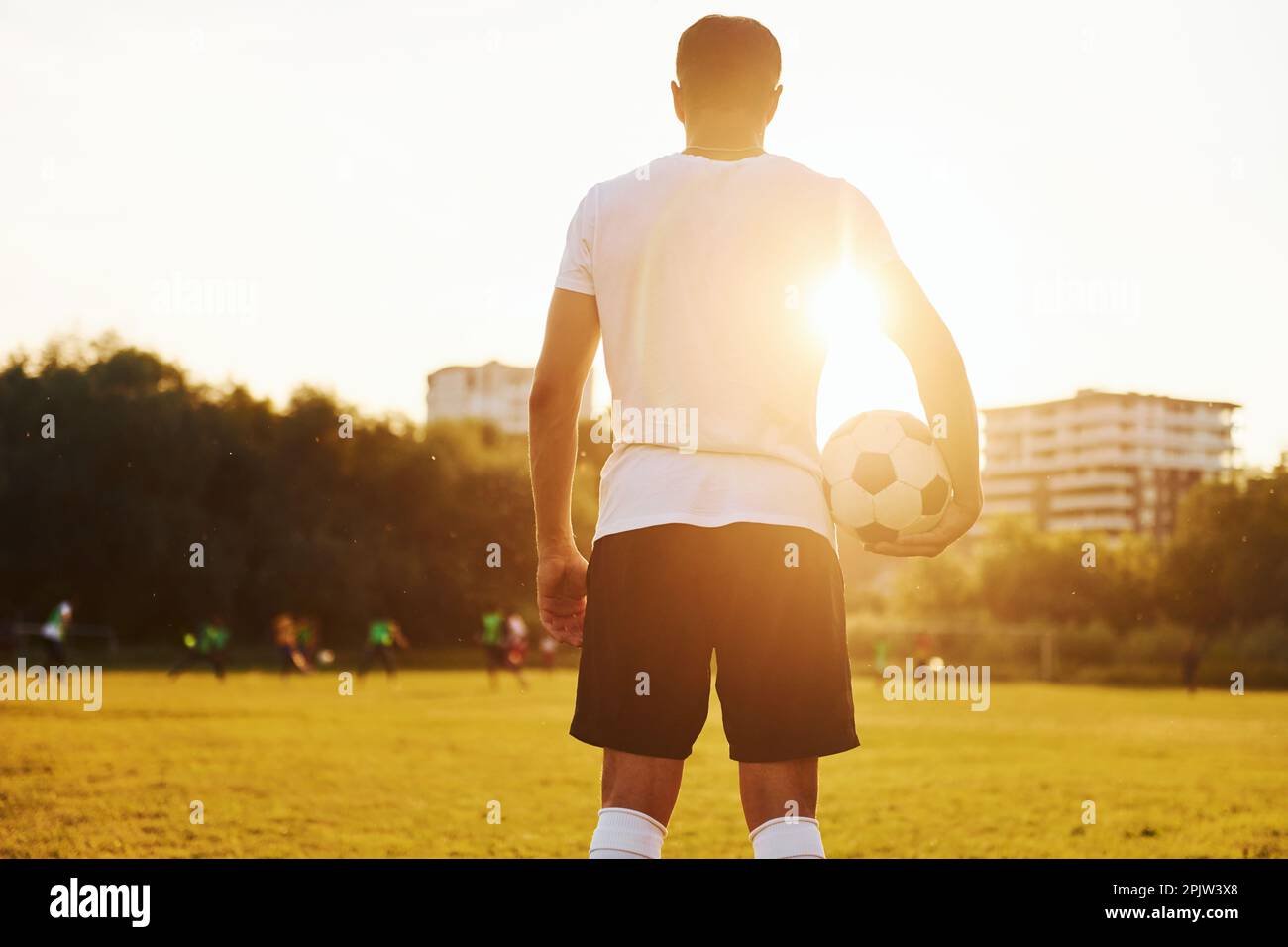 Standing and holding ball in hand. Young soccer player have training on ...