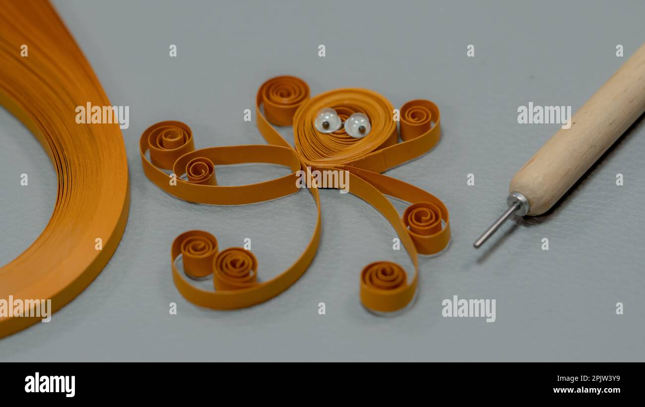 paper quilling crafts, paper octopus with a needle on a gray background ...