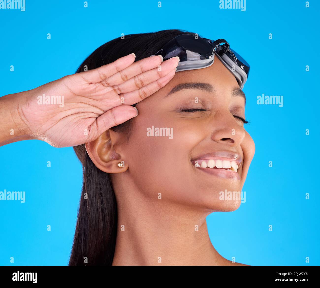 Face, smile and salute with a swimmer woman in studio on. a blue ...