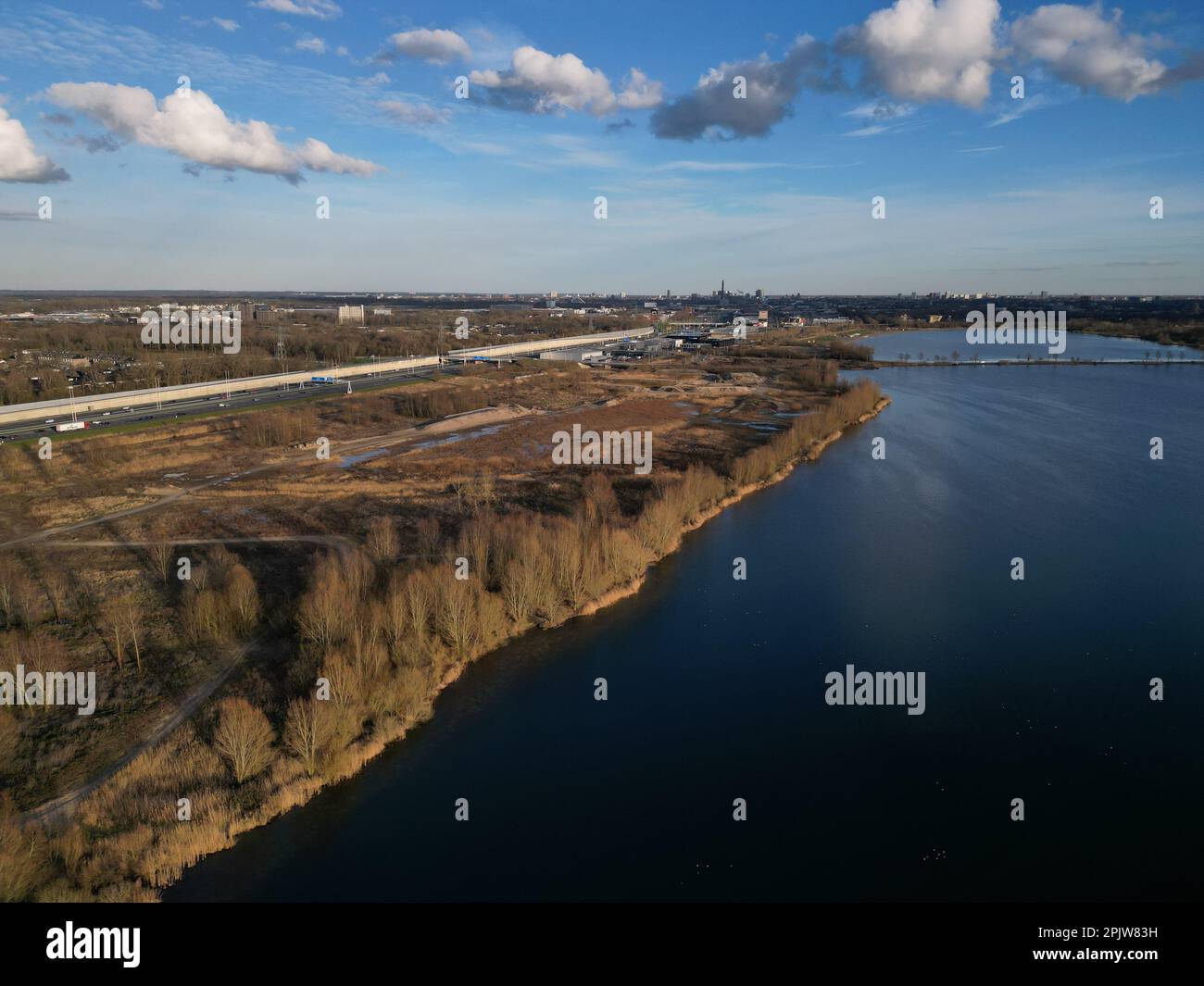 A scenic aerial view of a wide river meandering through an urban ...