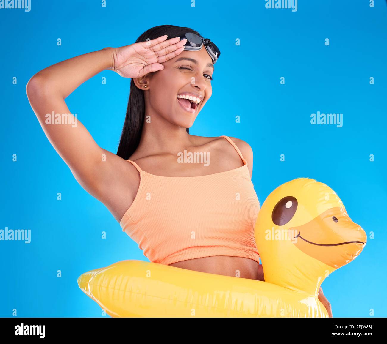 Portrait, smile and salute with a swimmer woman in studio on. a blue ...