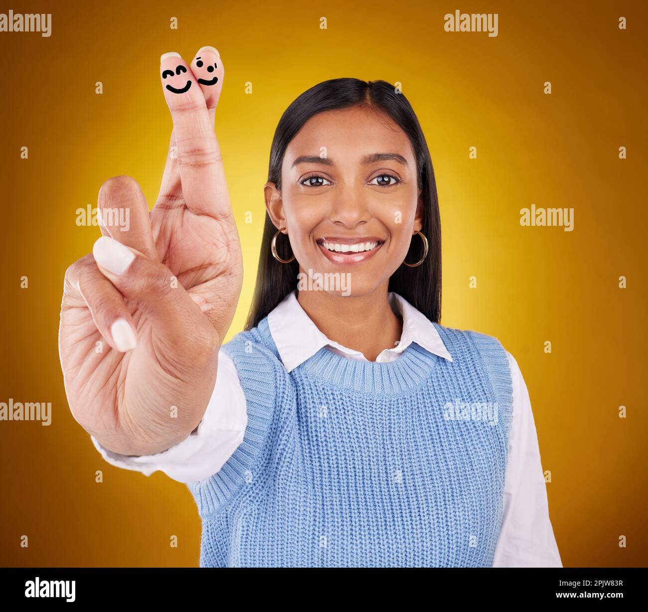 Smiley face, fingers crossed and portrait of Indian woman in studio ...