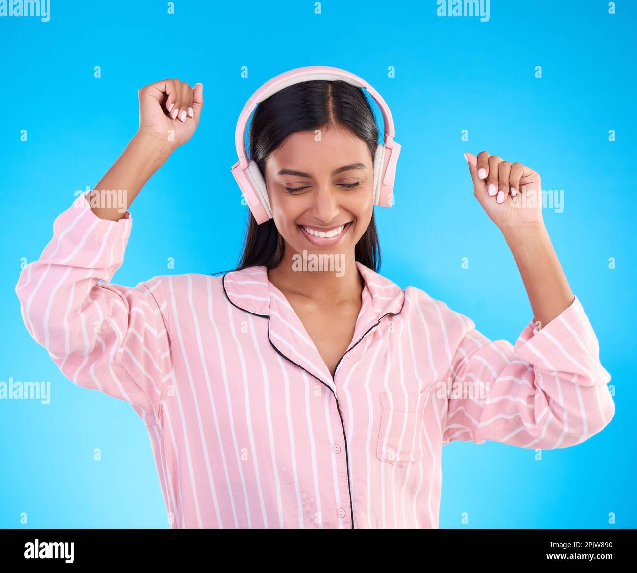 Happy, dance and woman in pajamas, headphones and cheerful on a blue ...