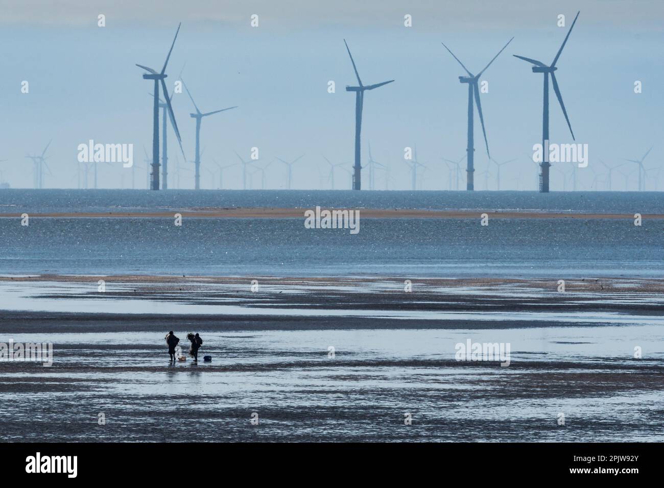 Fishernan on Crosby beach with giant windmills out in Liverpool Bay ...