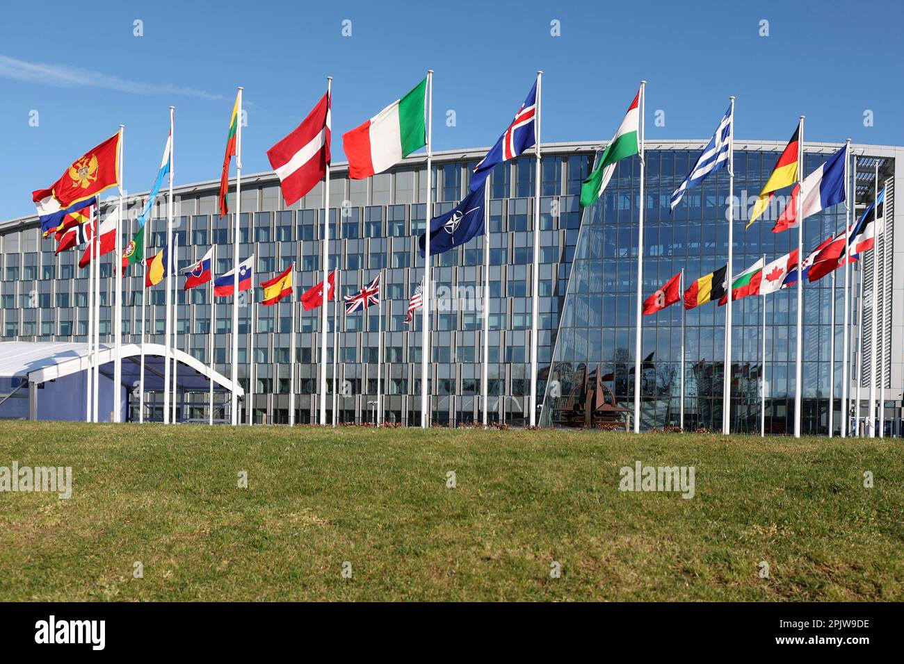 Flags of member nations flap in the wind outside NATO headquarters ...