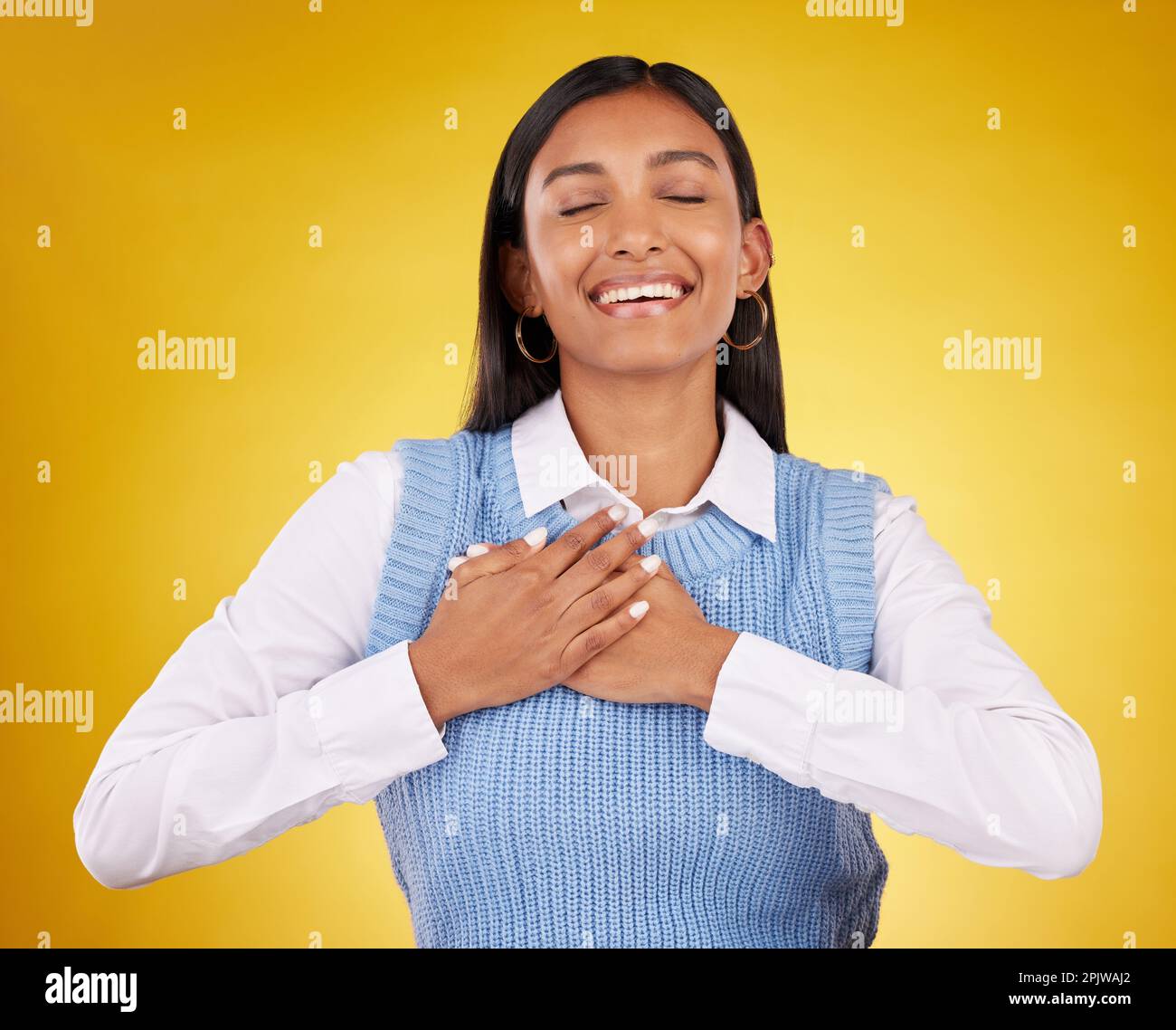 Gratitude, happy and young woman in a studio with her hand on her chest ...