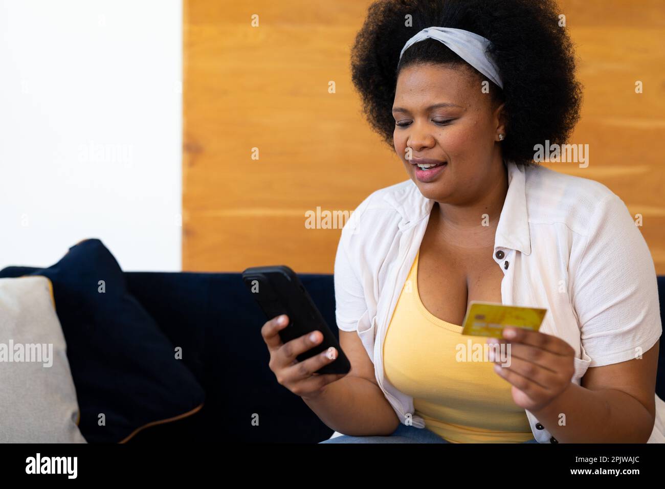 Happy Plus Size African American Woman On Sofa Online Shopping With