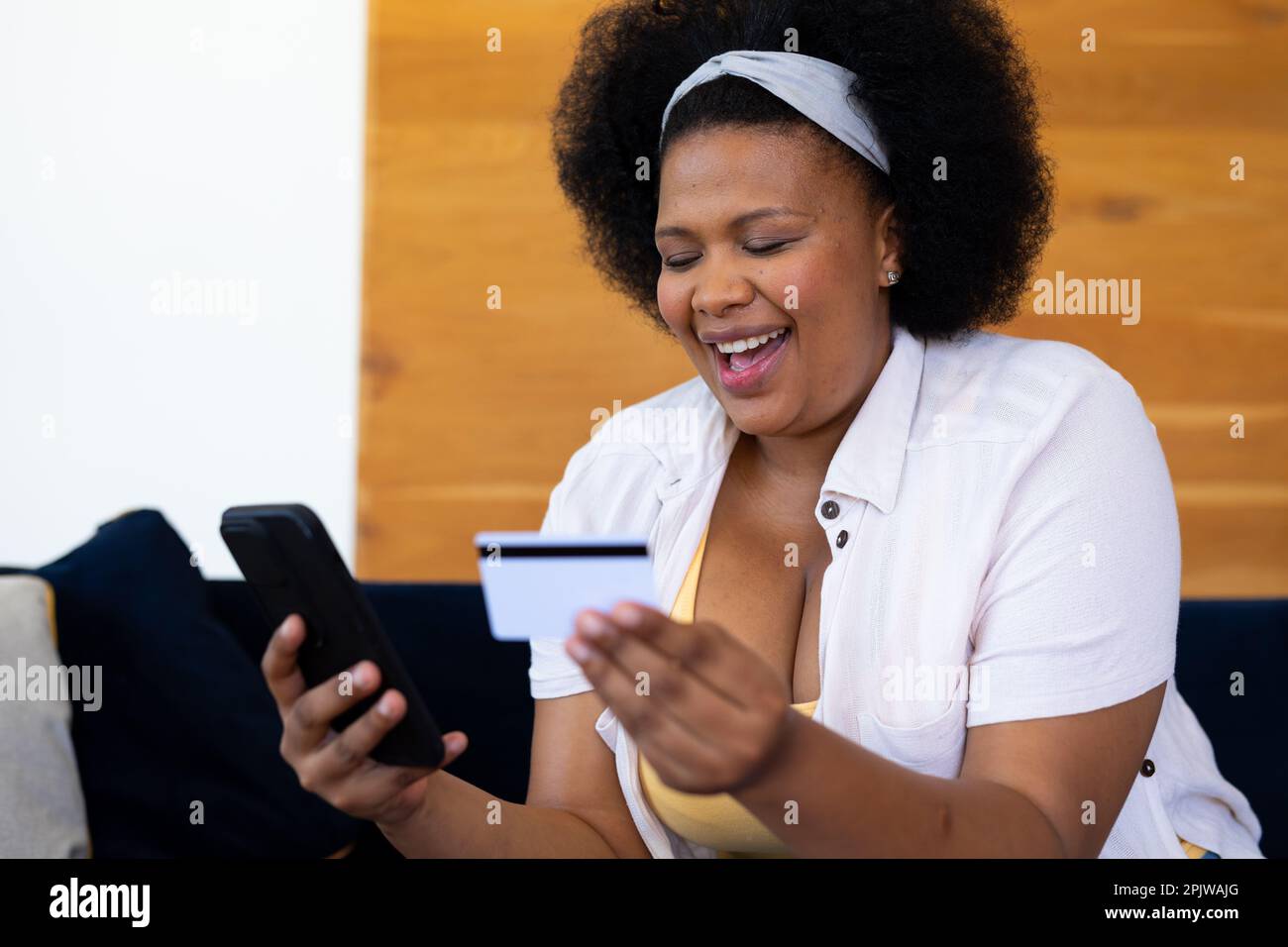 Happy plus size african american woman on sofa online shopping with ...