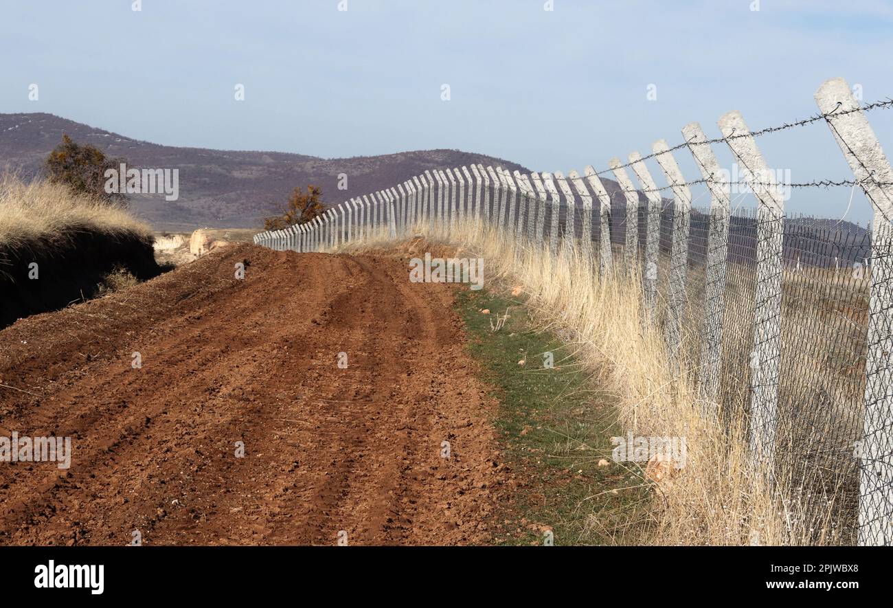 Dirt road passing in the middle of farms with fence Stock Photo - Alamy