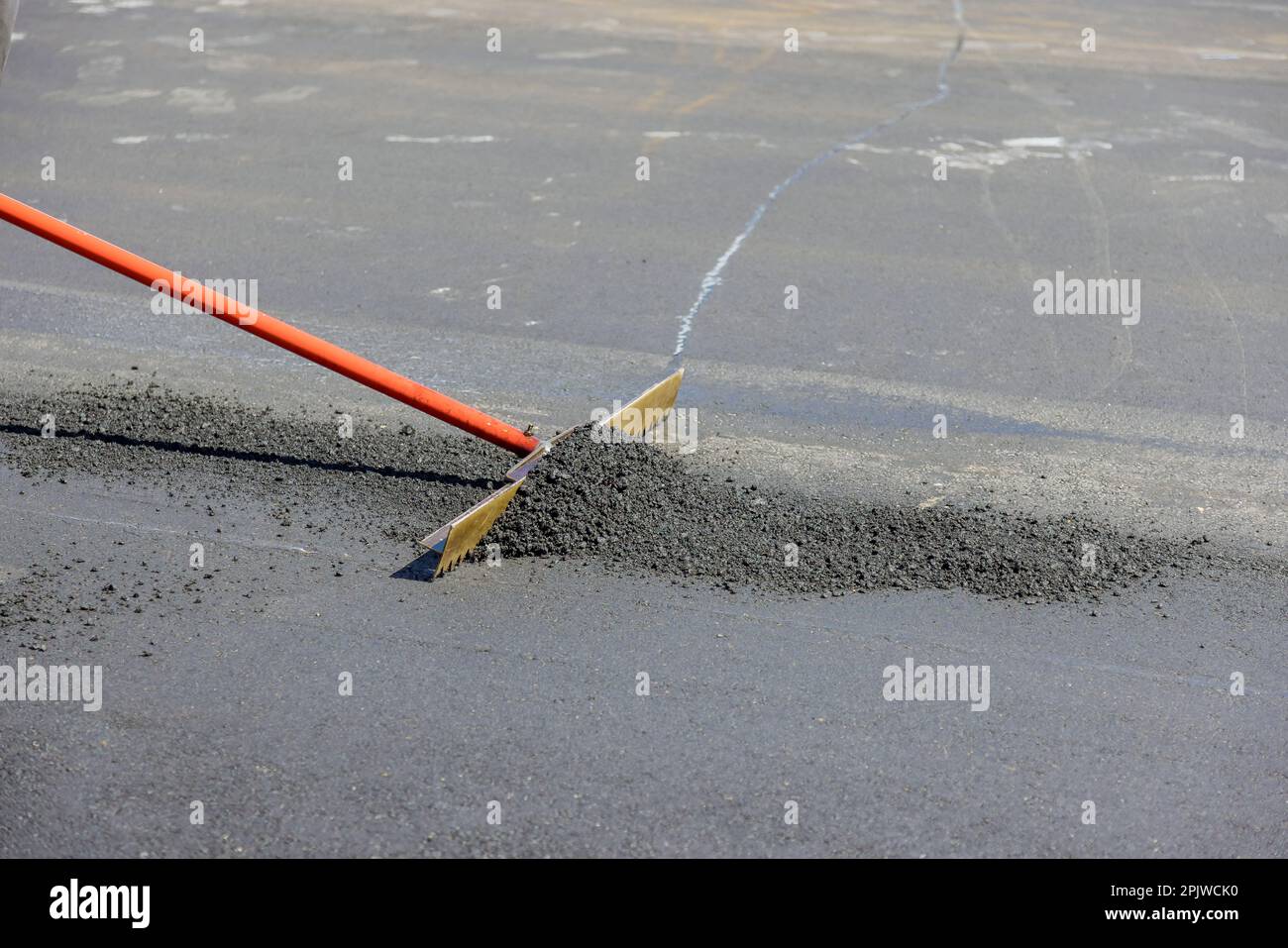 It is evident that construction worker is in process of laying asphalt ...