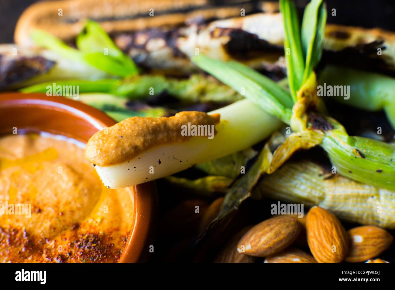 Calçots with romesco sauce. Calçots are a variety of tender onion that ...