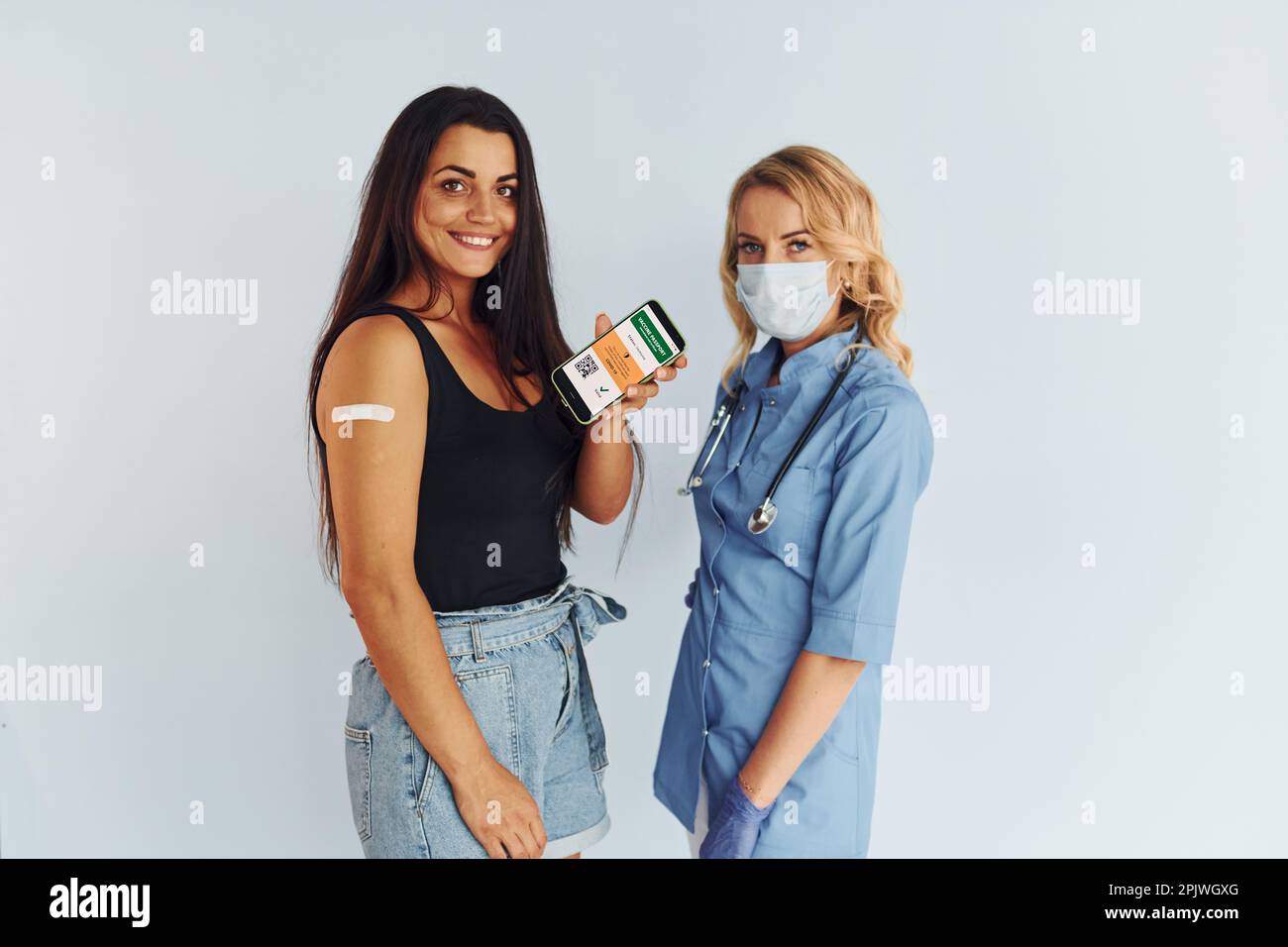 With digital passport. Doctor in uniform making vaccination to the ...