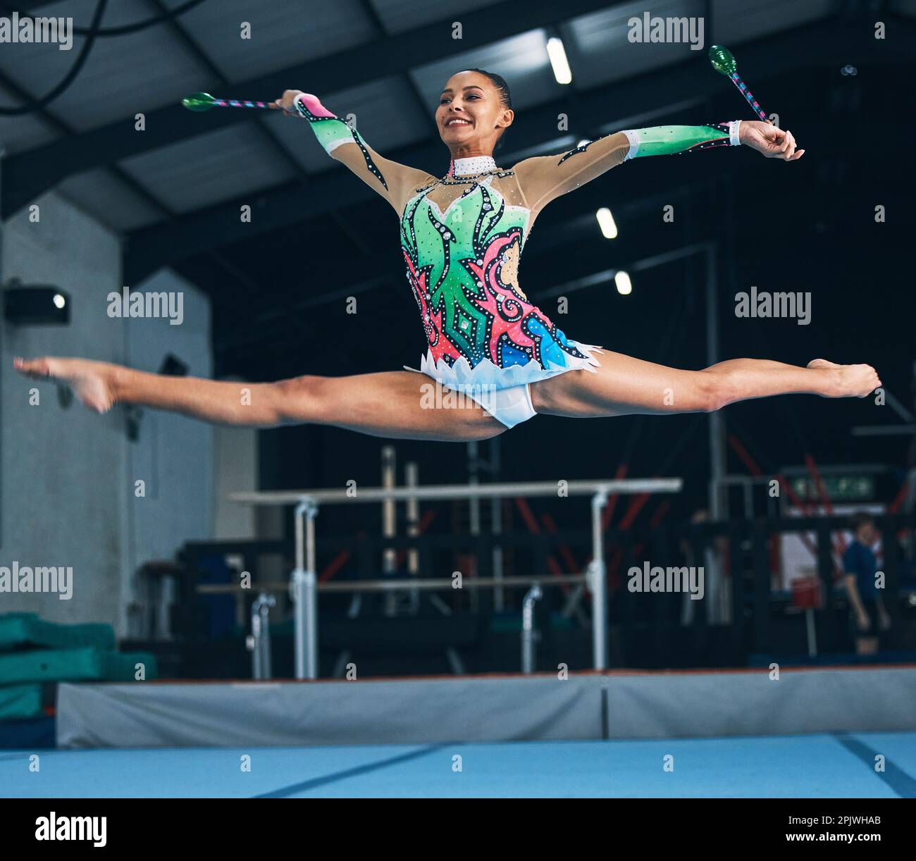 Sports, gymnastics and woman jumping with a ribbon in a professional ...