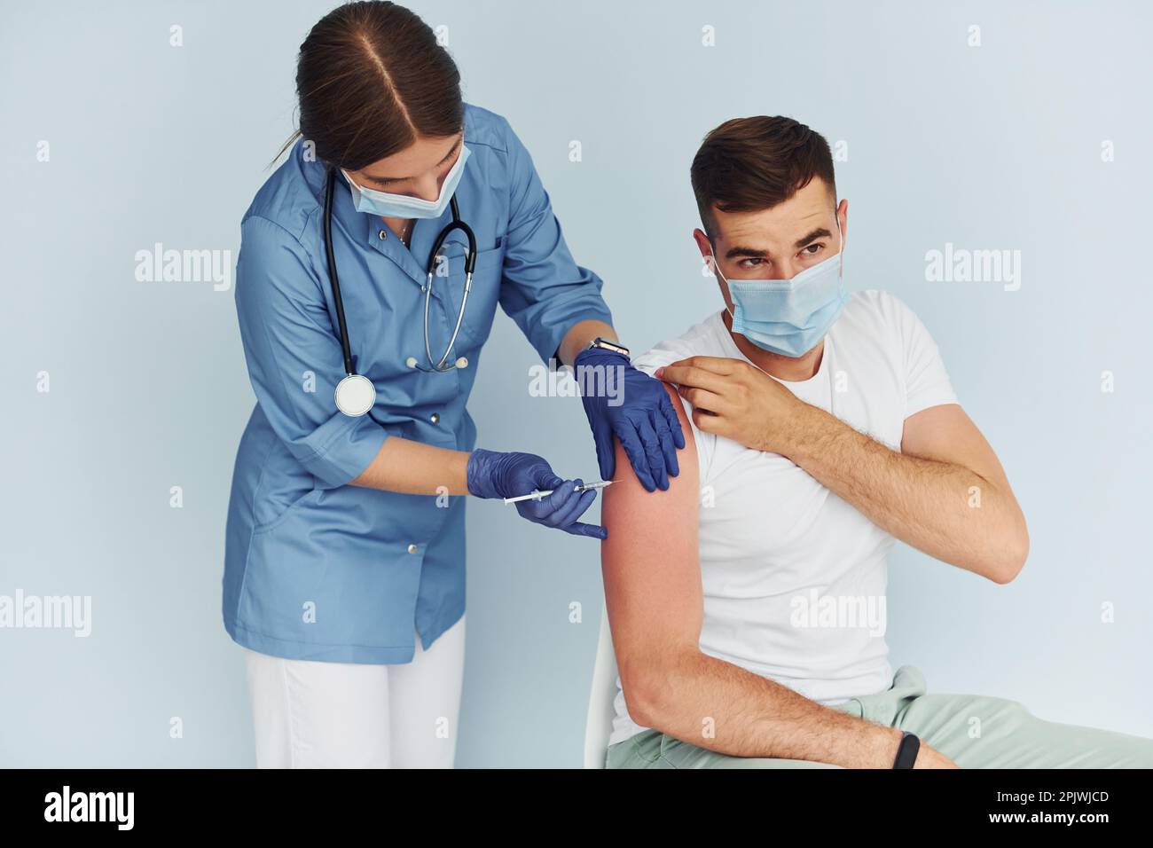 Using syringe. Doctor in uniform making vaccination to the patient ...