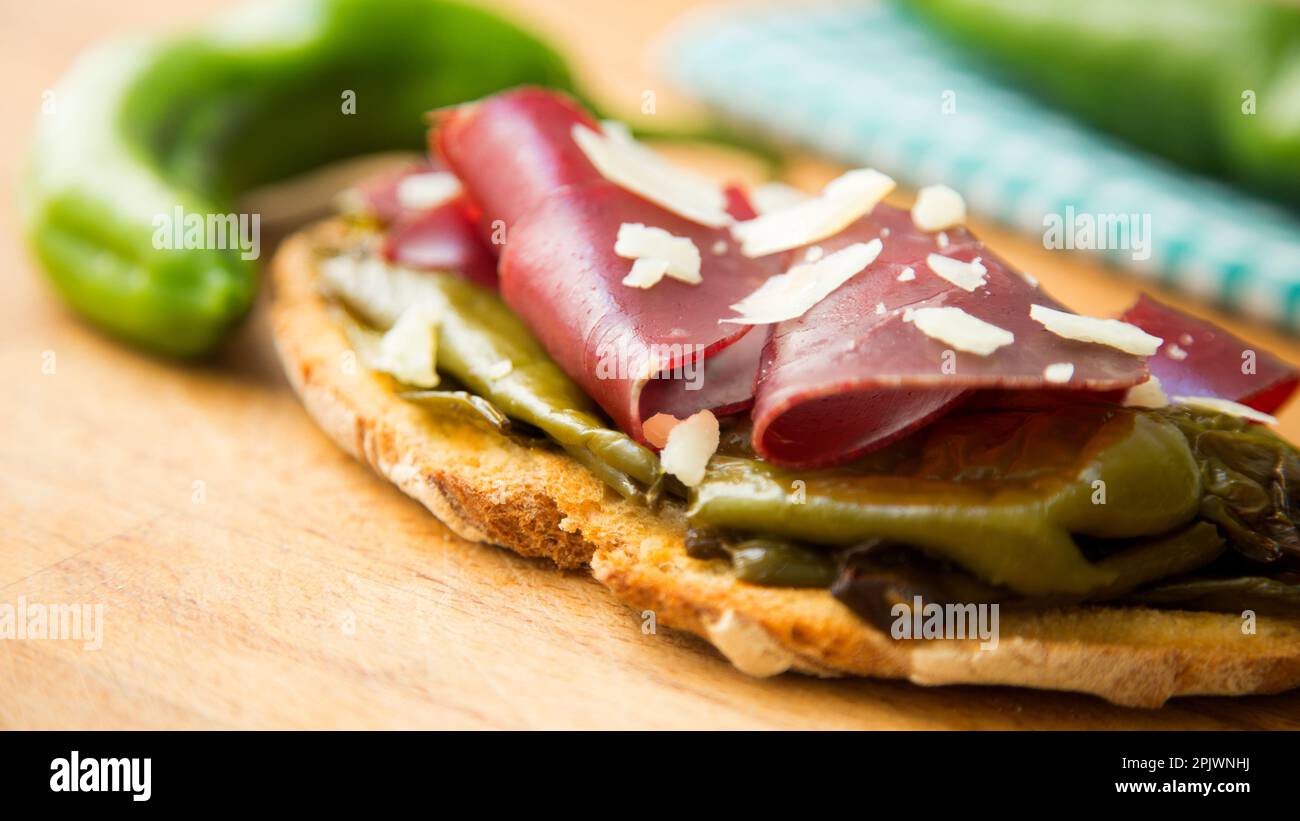 Traditional cecina tapa with fried green peppers. Cecina is a type of ...