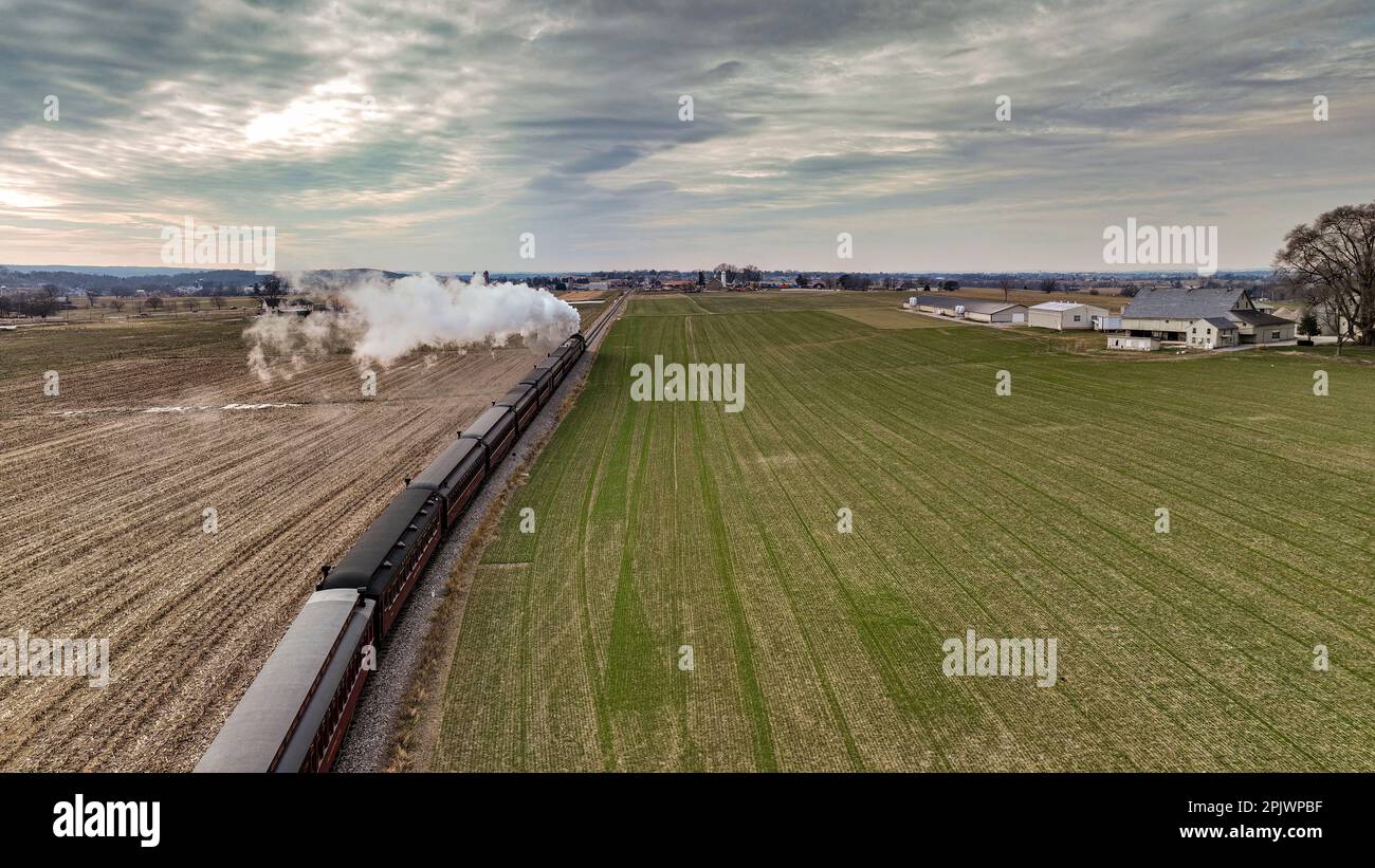 A vintage locomotive train chugging along railroad tracks in a scenic ...