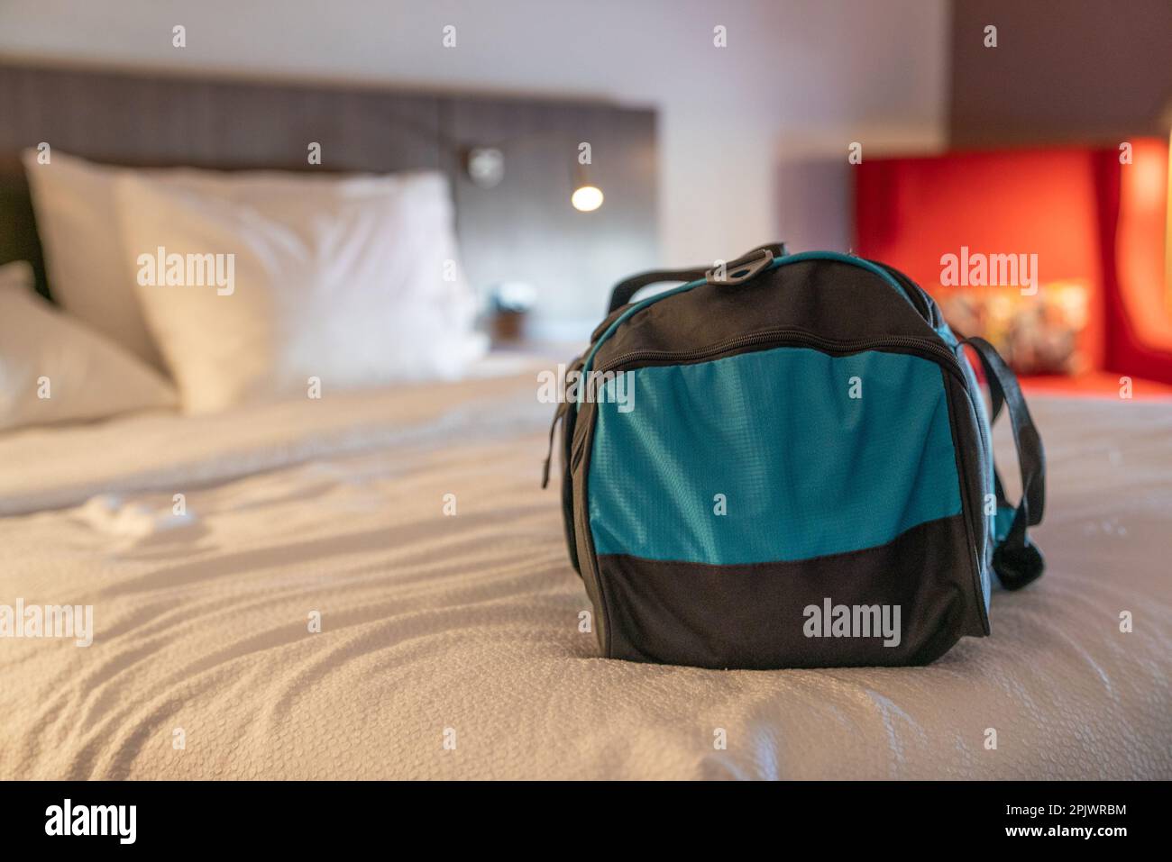 Small travel bag on the bed of a hotel room Stock Photo - Alamy