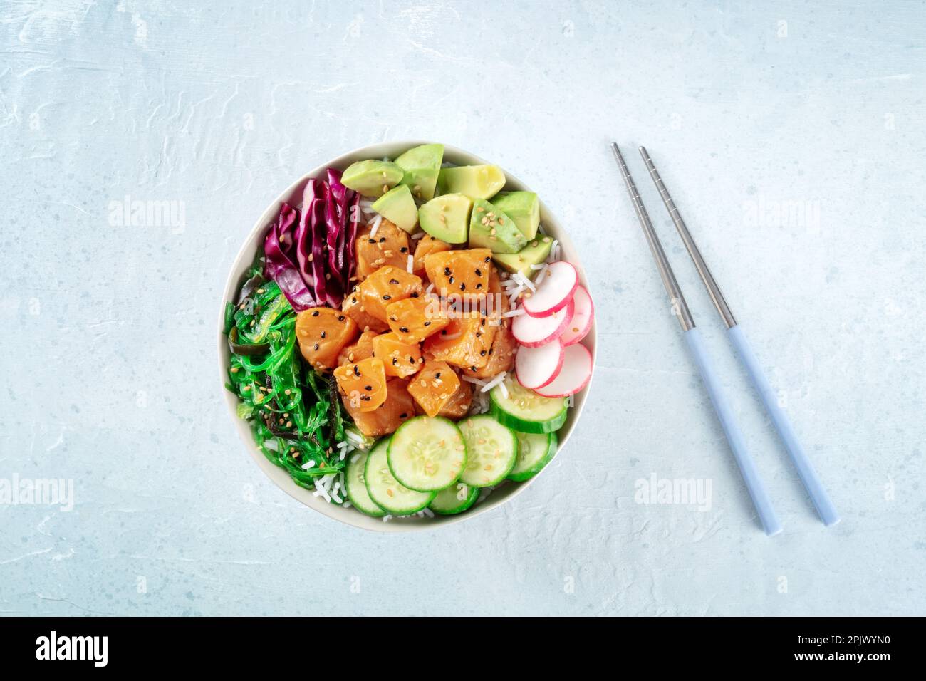 Salmon poke bowl with avocado, cucumbers, wakame, radish, and purple ...