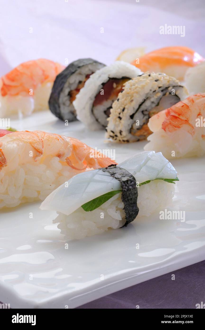 A tray with mixed japanese raw fish, seawood and rice; sushi; sashimi ...