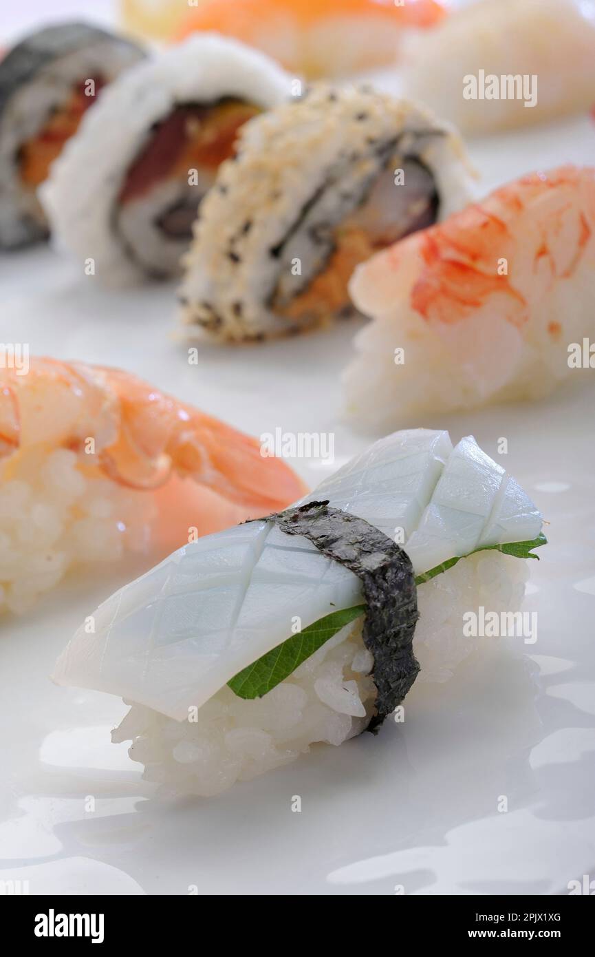 A tray with mixed japanese raw fish, seawood and rice; sushi; sashimi ...