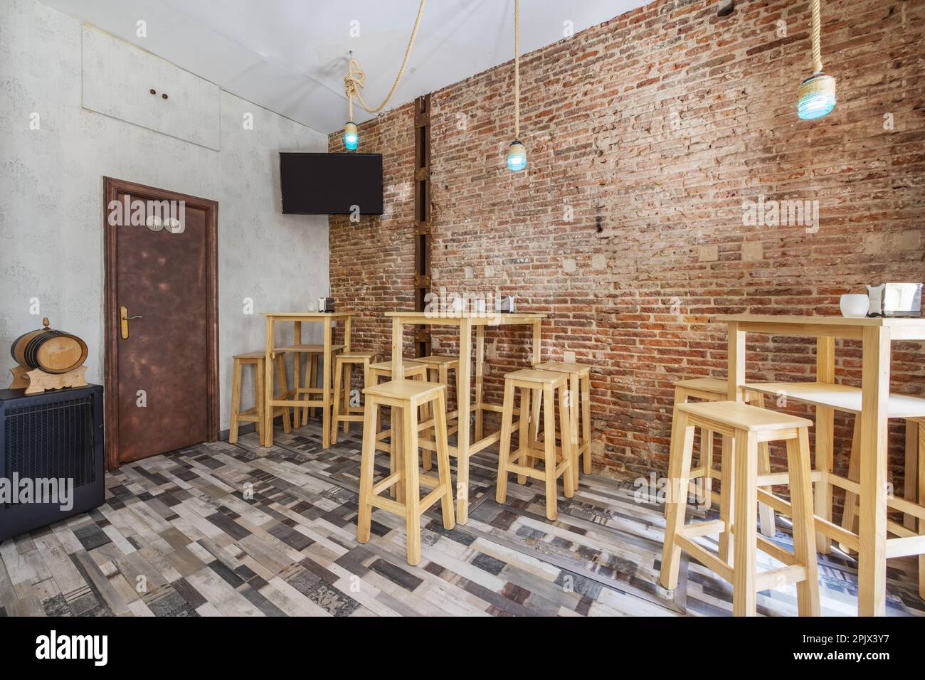 An empty bar with a rope lamp, a ceiling fan, raw brick walls and high ...