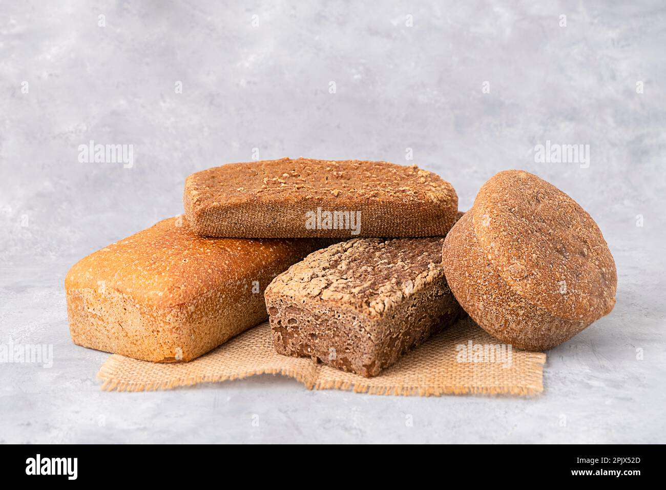 Different types of sourdough bread on light grey background with copy ...