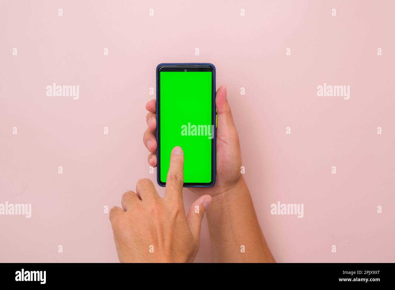 Human hand using mobile smartphone with mockup green screen on pink ...