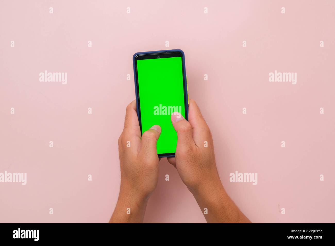 Human hand using mobile smartphone with mockup green screen on pink ...