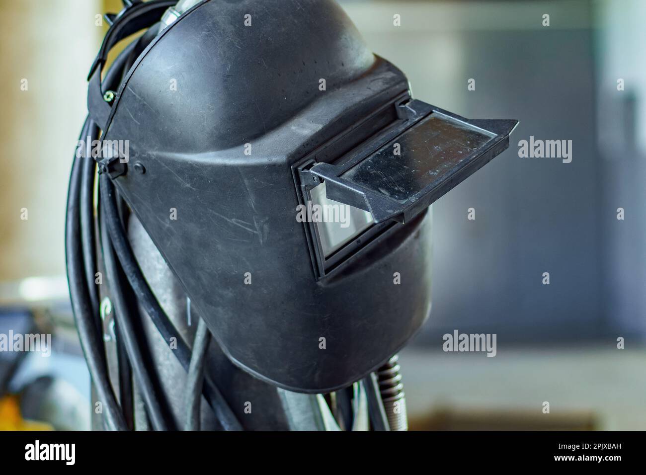 Welder's protective mask hangs on oxygen cylinder in production hall ...