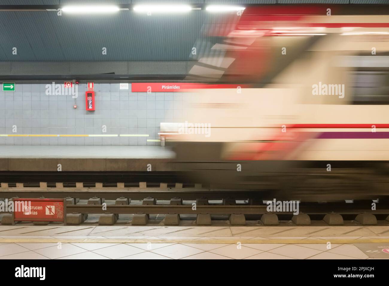 A blurred view of a train entering into view of the right of the photo ...
